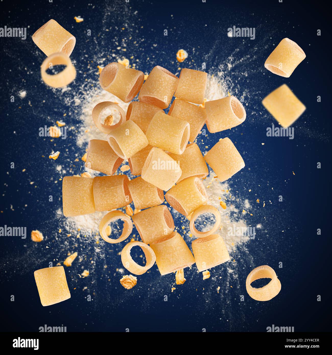 Raw tubetti lisci pasta exploding on a blue background, creating a ...