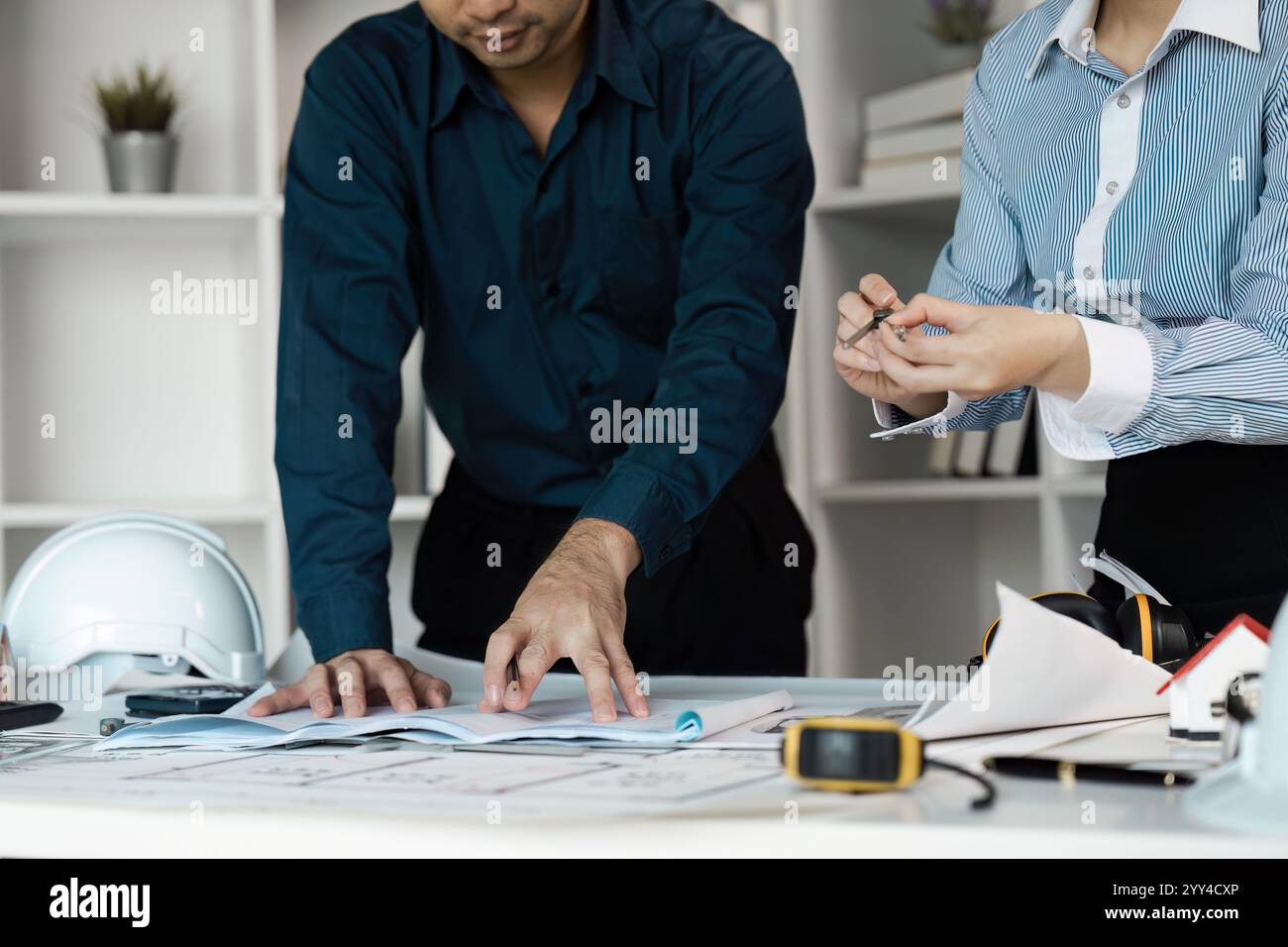 Engineers Collaborating on Architectural Project with Blueprints and ...