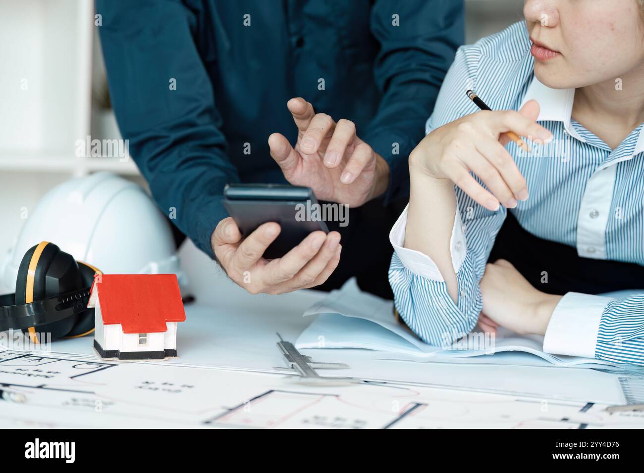 Engineers Collaborating on Architectural Design Plans with Modern ...