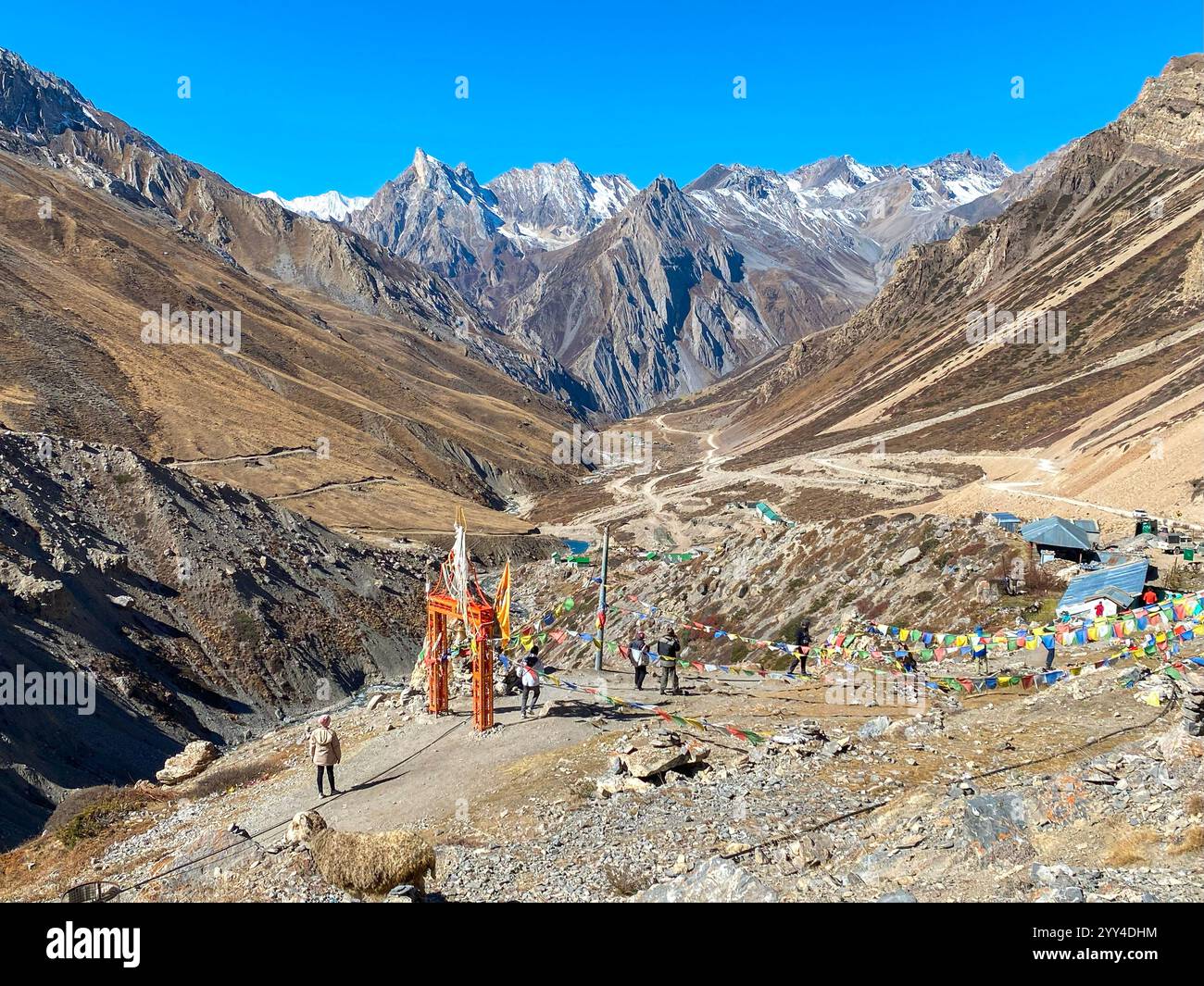 Sacred gate with flags and temple bell on the road leading to Om Parvat ...