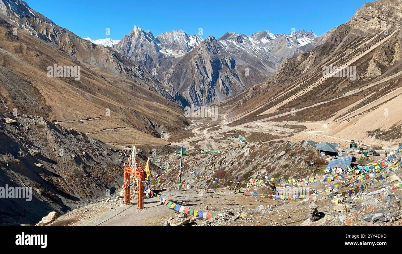 Sacred gate with flags and temple bell on the road leading to Om Parvat ...