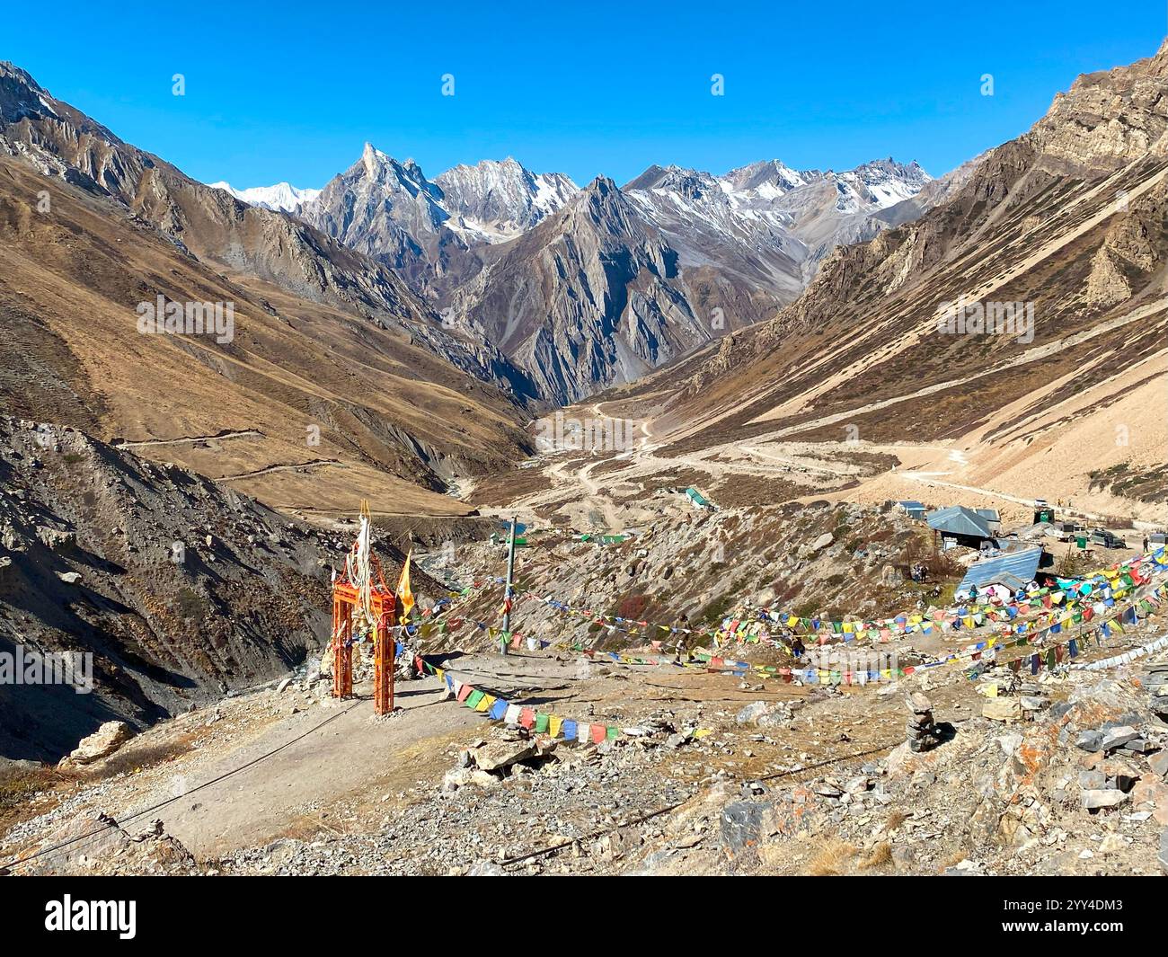 Sacred gate with flags and temple bell on the road leading to Om Parvat ...