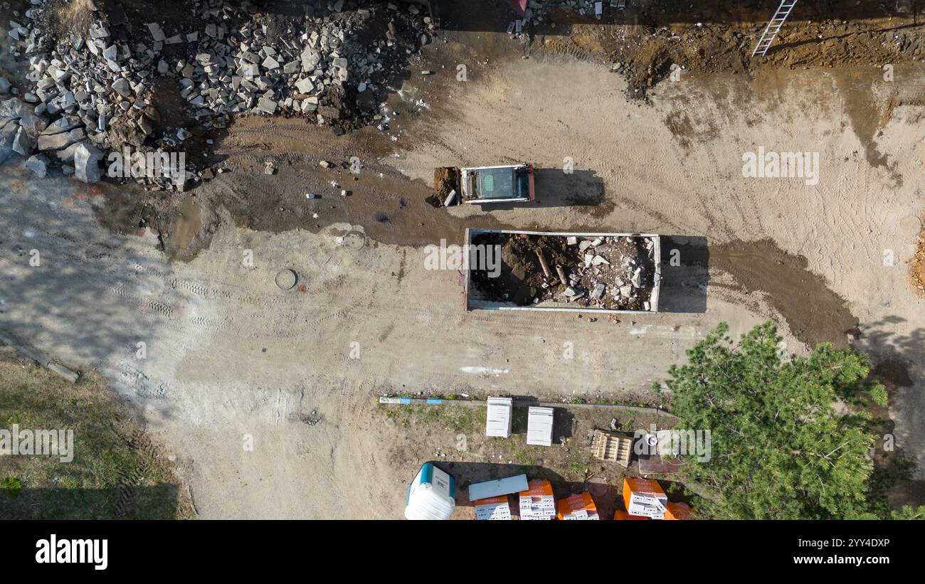 Aerial view of a construction site with a truck loading debris into a ...