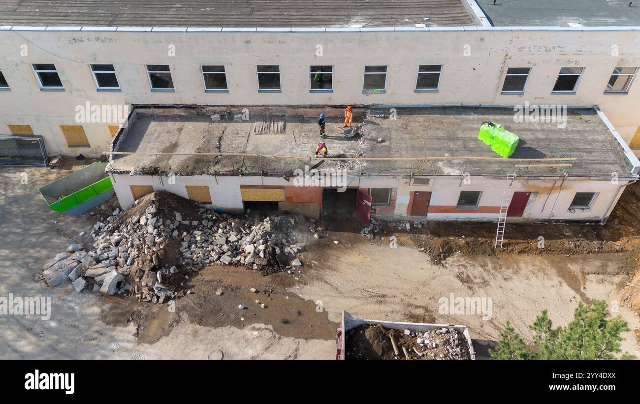 Aerial view of a construction site with workers on a flat roof ...