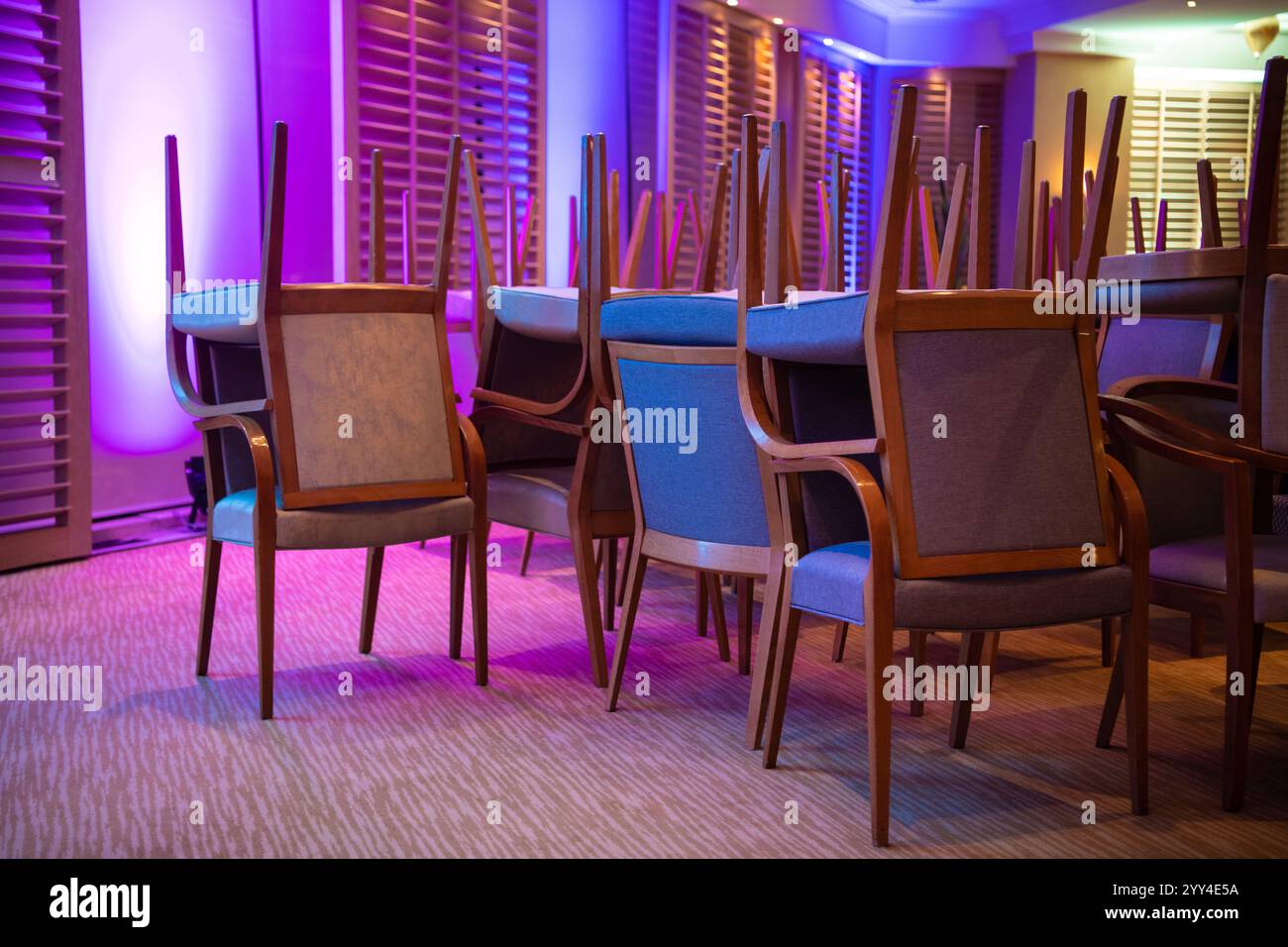 Chairs and tables stacked in empty closed local bar and restaurant ...