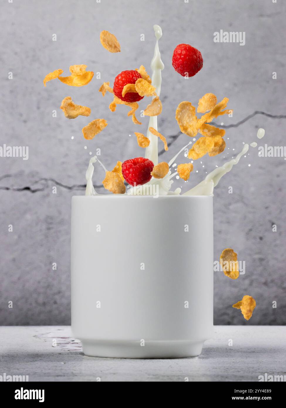 Floating raspberries and cereal flakes captured mid-splash with plant ...