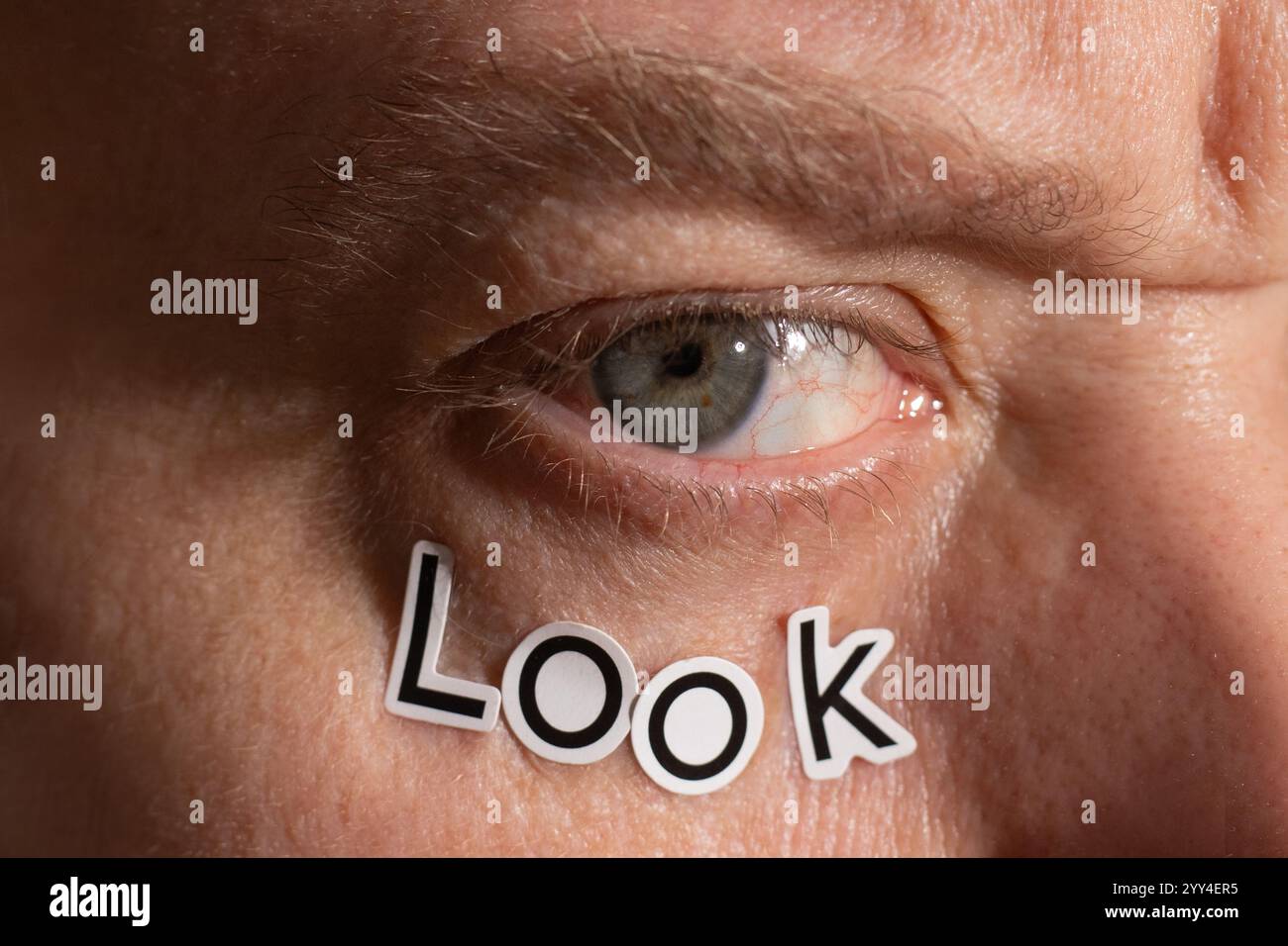 A detailed close-up image depicts a human eye with the word look placed ...