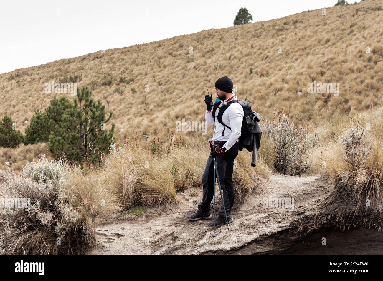 A black man in mountaineering gear, equipped with a backpack and ...
