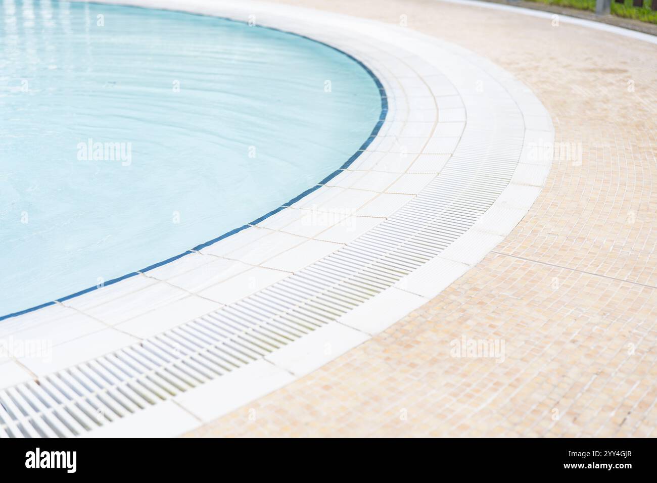 A tranquil view of a curved outdoor pool with clear blue water The ...