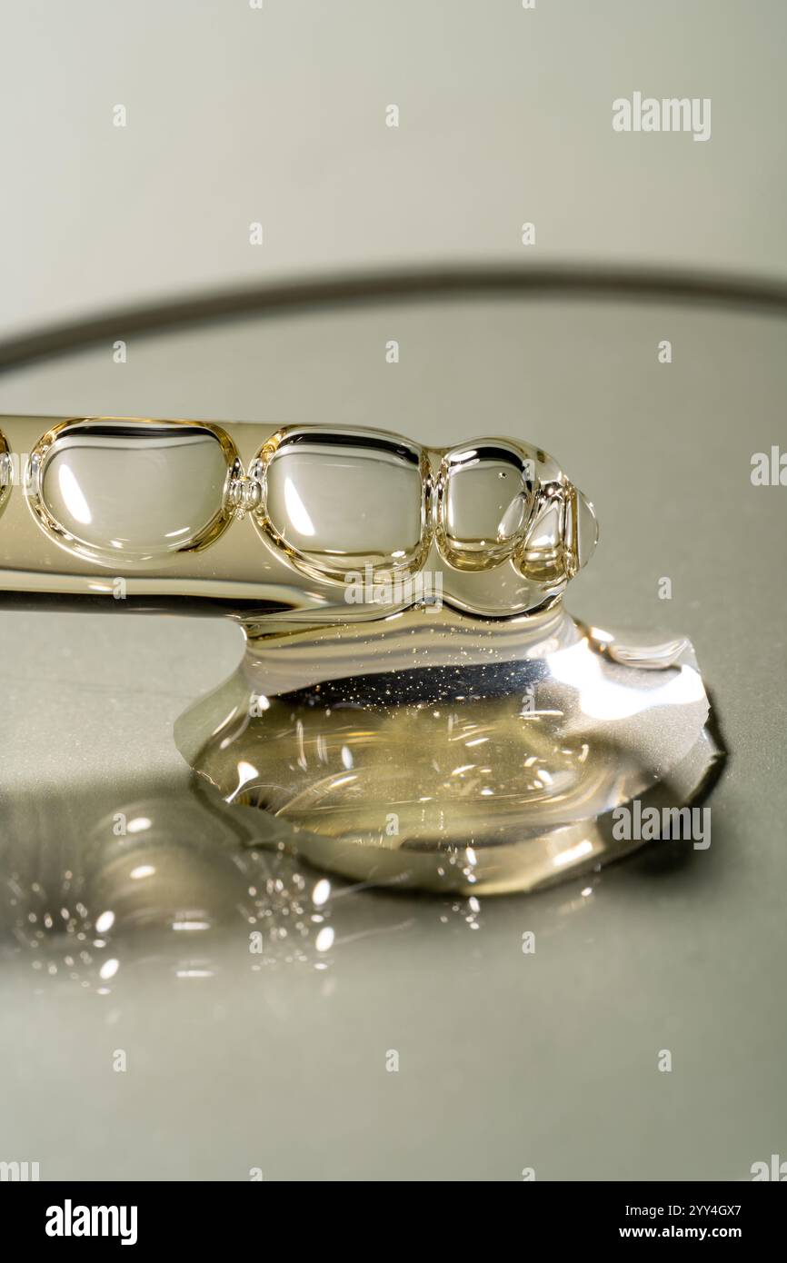 A close-up image showcases transparent liquid bubbles on a reflective ...