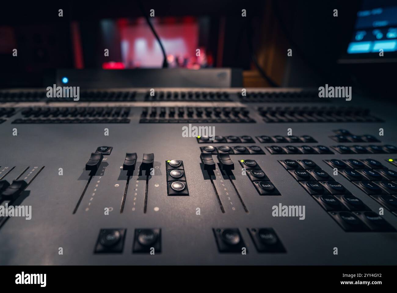 A detailed view of a professional sound mixer with sliders and buttons ...