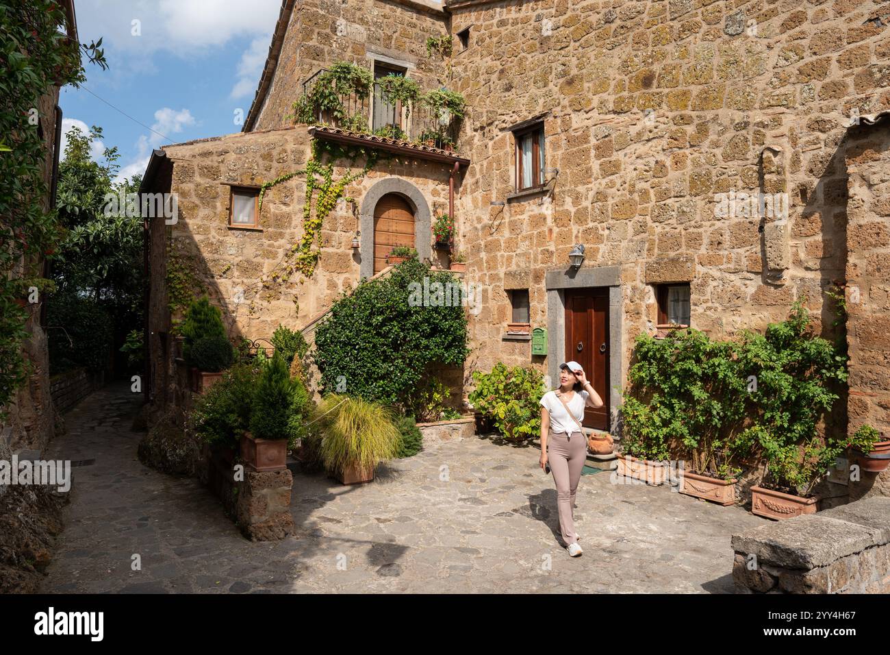A woman strolls through a quaint Italian village, passing by a charming ...