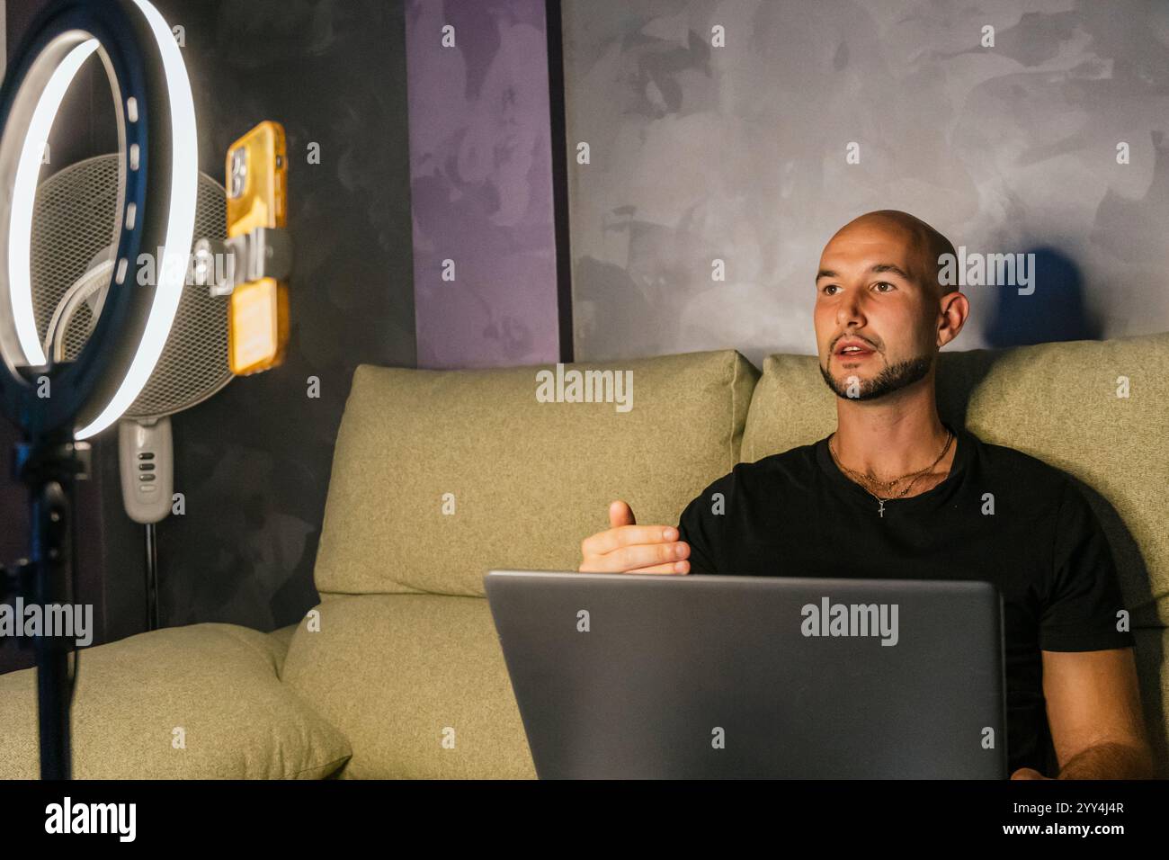 A man records content with professional lighting and smartphone setup ...