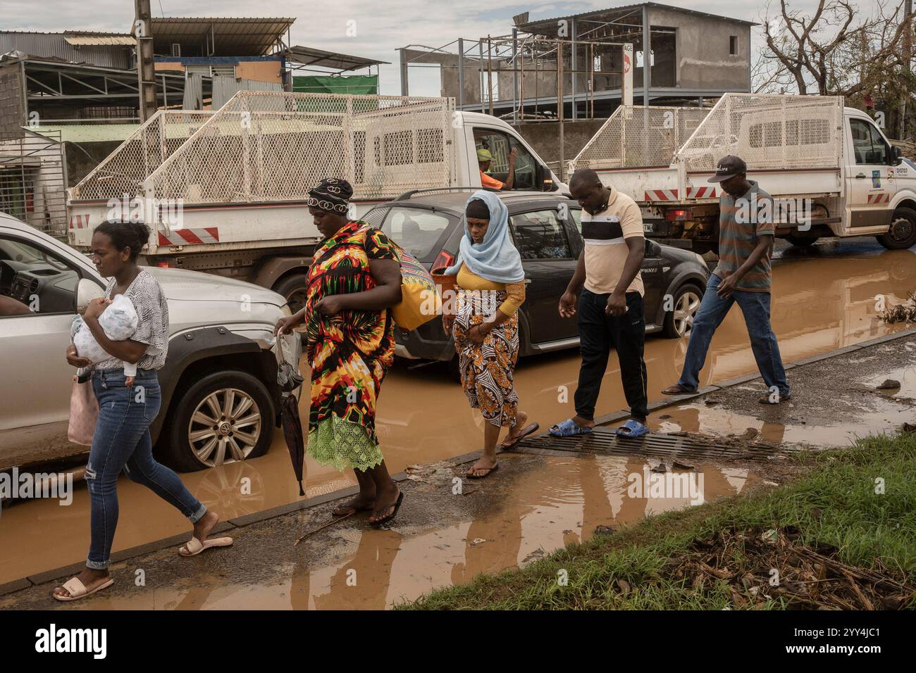 People walk along partially flooded roads, in Mamoudzou, Mayotte ...