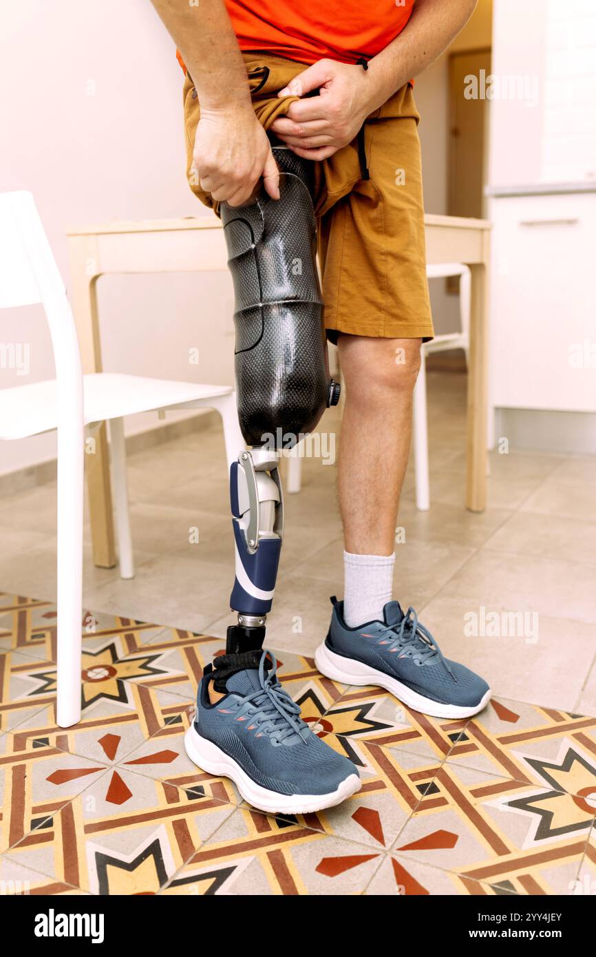 A man is seen adjusting his advanced prosthetic leg in a cozy, indoor ...