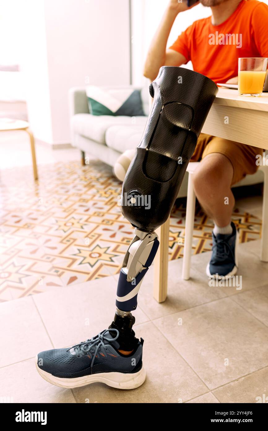 A man with a prosthetic leg relaxes in a modern living room ...
