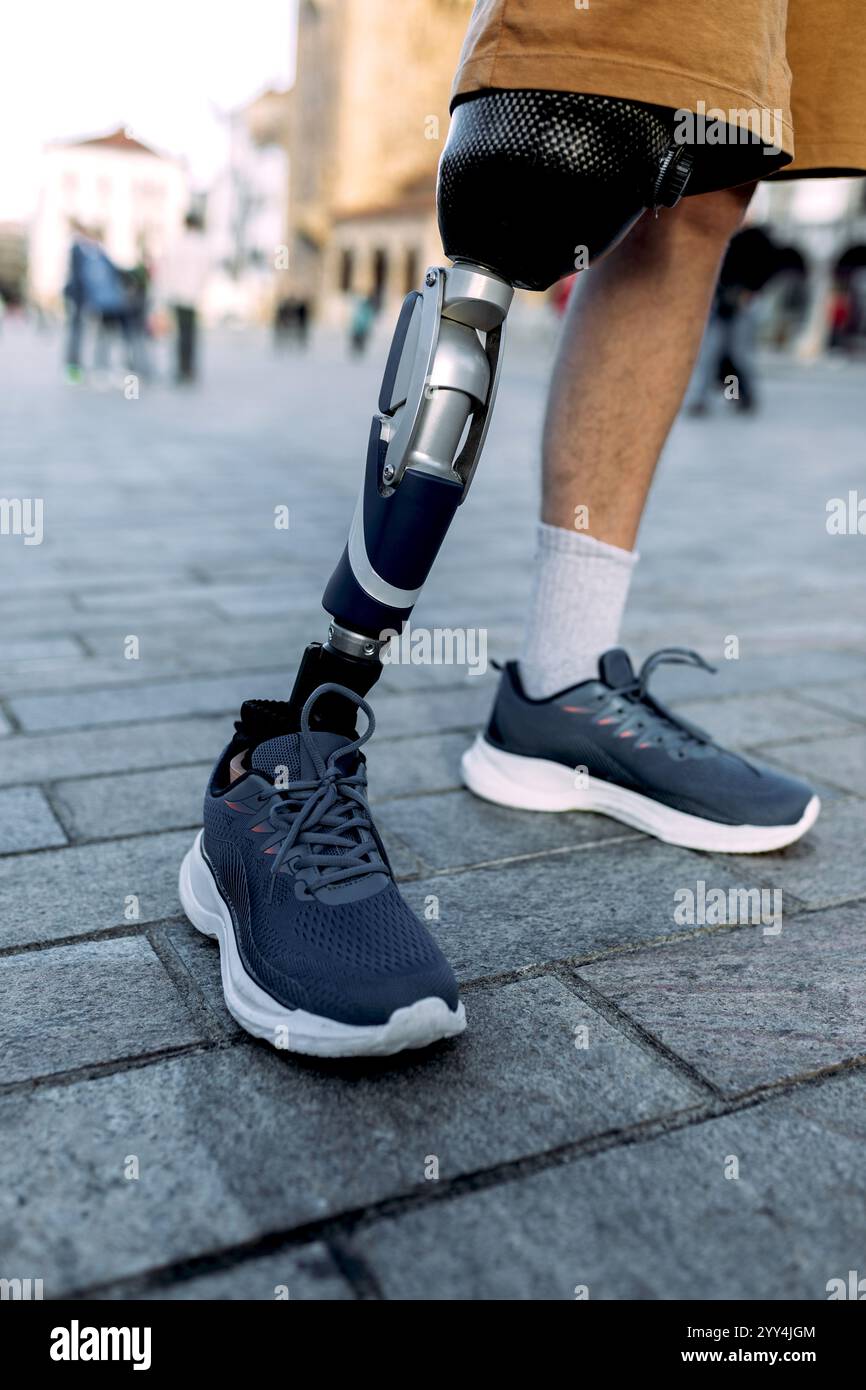 Close-up of a prosthetic leg in a sneaker, standing on an urban street ...
