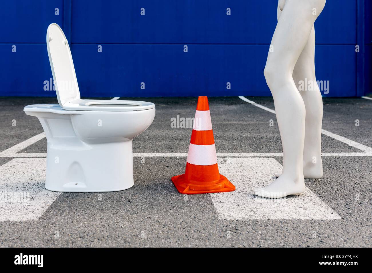 A bizarre scene featuring a white toilet, orange traffic cone, and ...