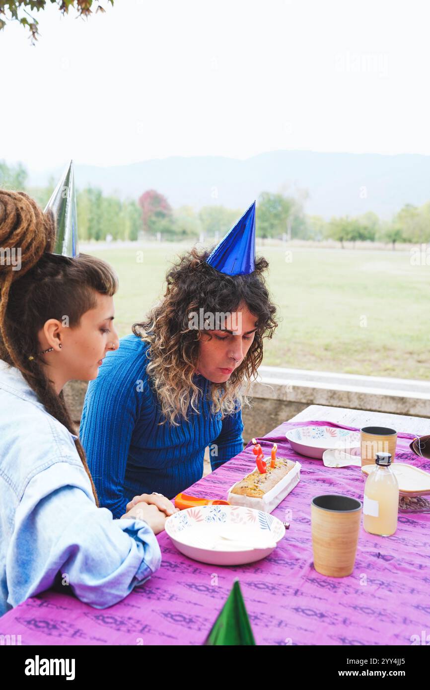 A transgender couple enjoys a birthday celebration outdoors, with one ...