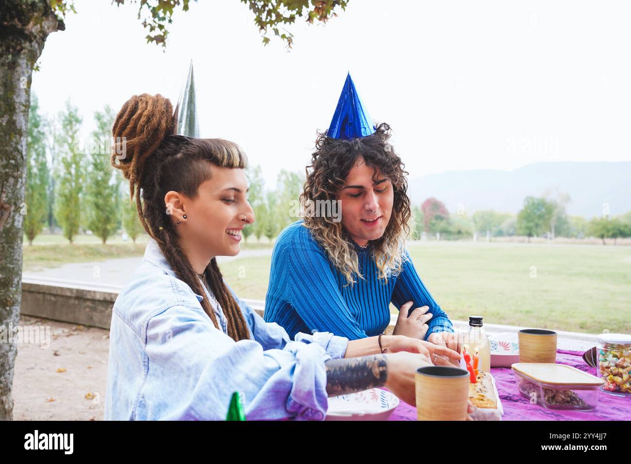 Transgender couple in celebrations outdoors with a picnic setup. The ...