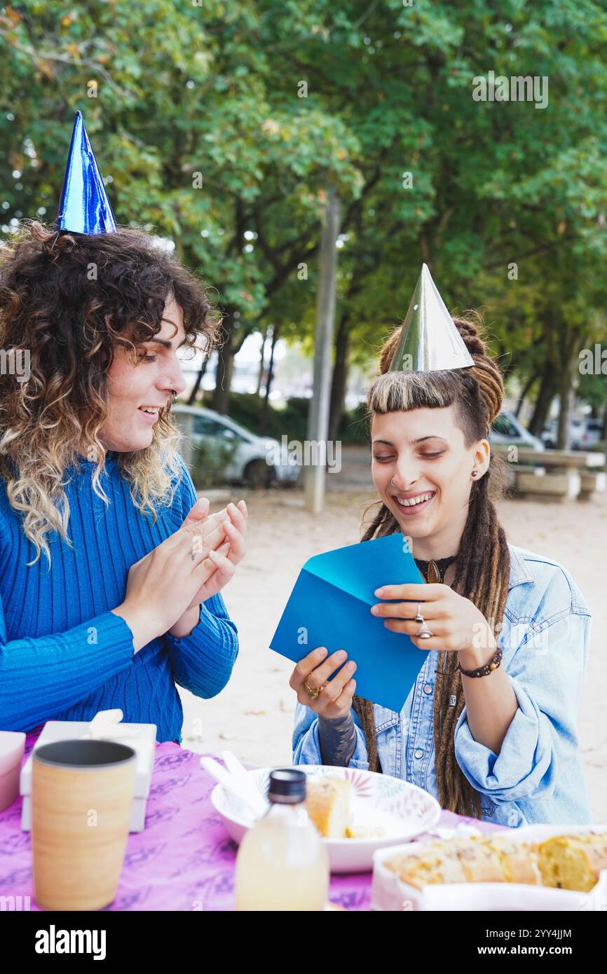 A transgender couple enjoys a birthday celebration moment outdoors ...