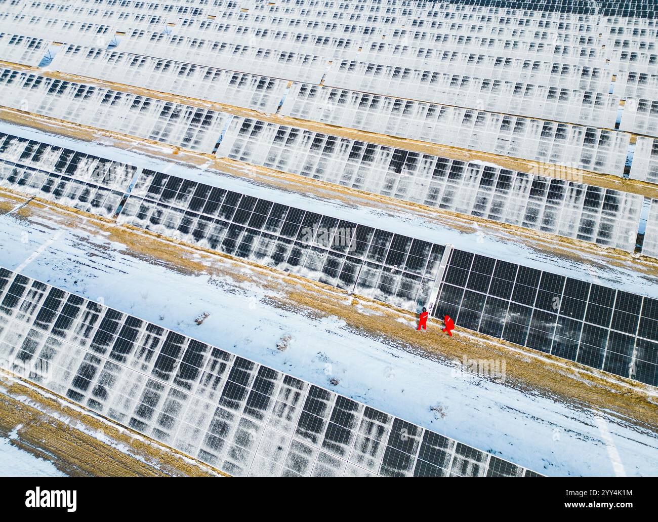 Operation and maintenance personnel clean snow on photovoltaic modules ...