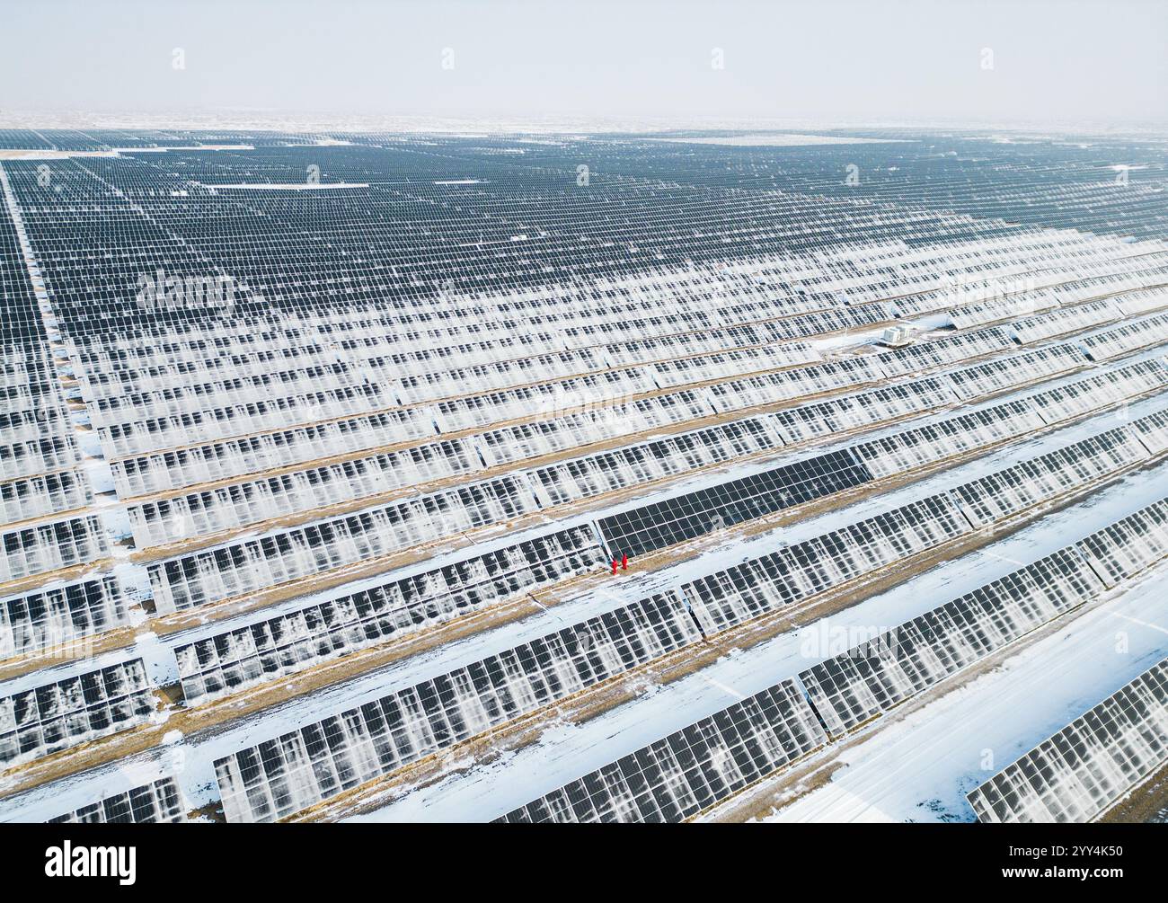 Operation and maintenance personnel clean snow on photovoltaic modules ...