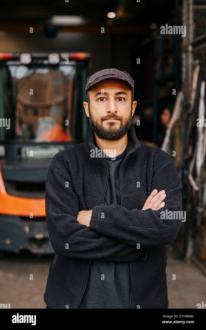 Portrait of male manufacturing professional wearing cap while standing ...