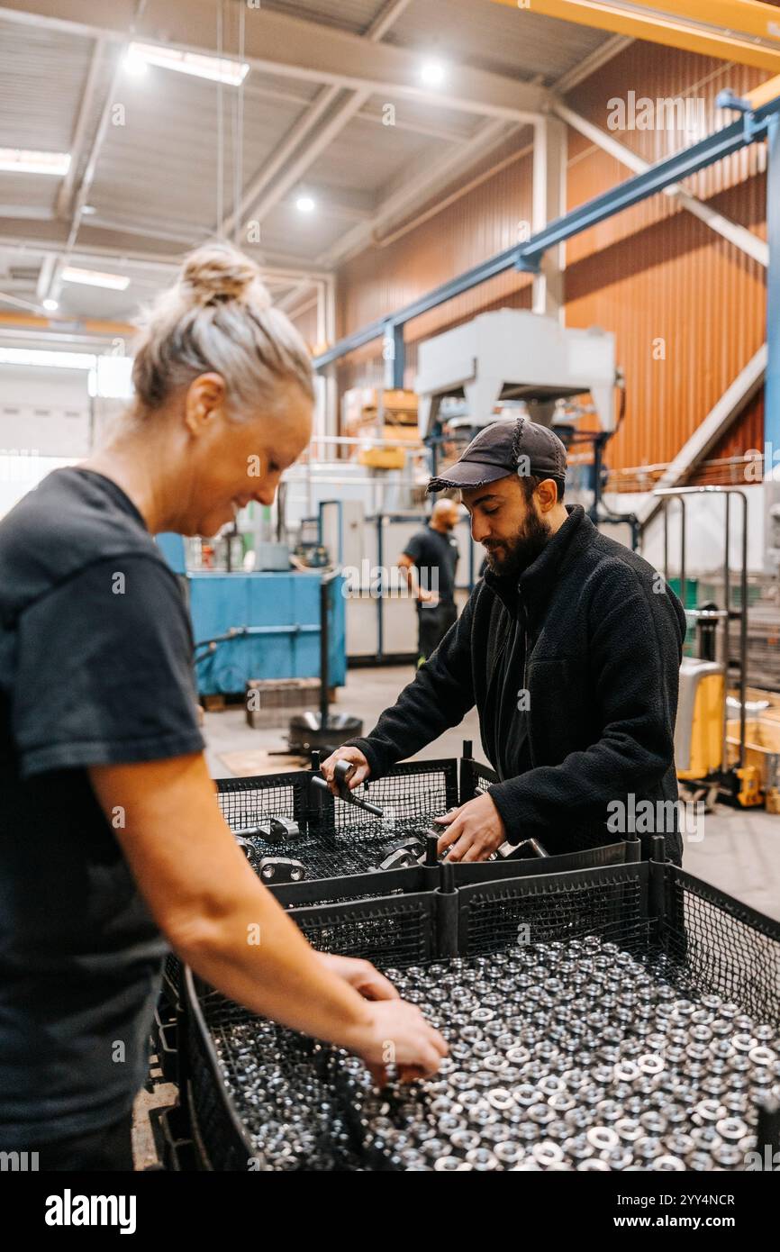 Multiracial female and male employees examining ball bearings in ...