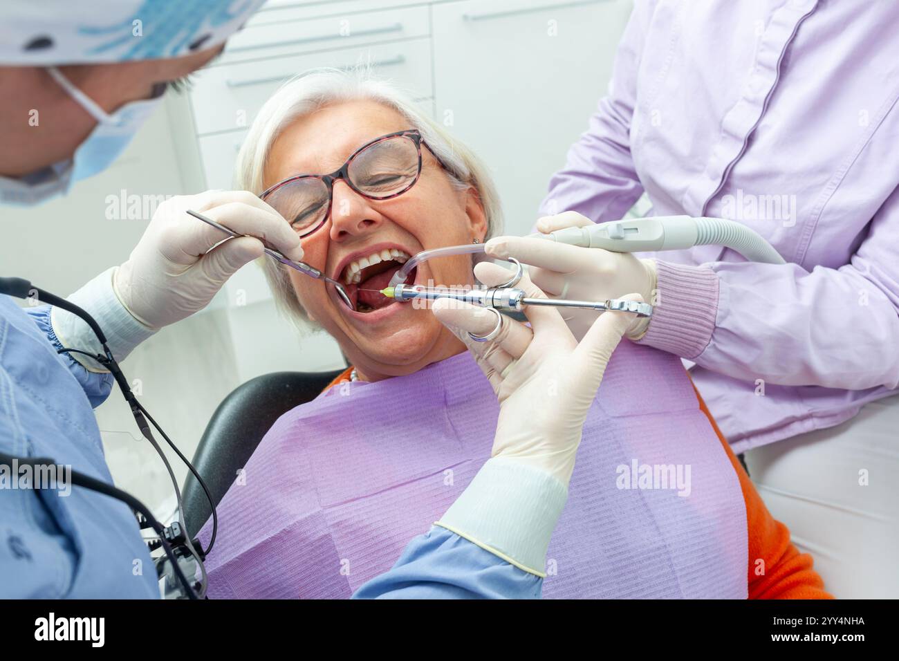 Dentist and assistant working together, performing a dental procedure ...