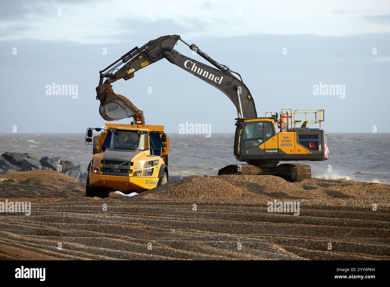 A Volvo A40E tipper truck is loaded with shingle by a caterpillar ...