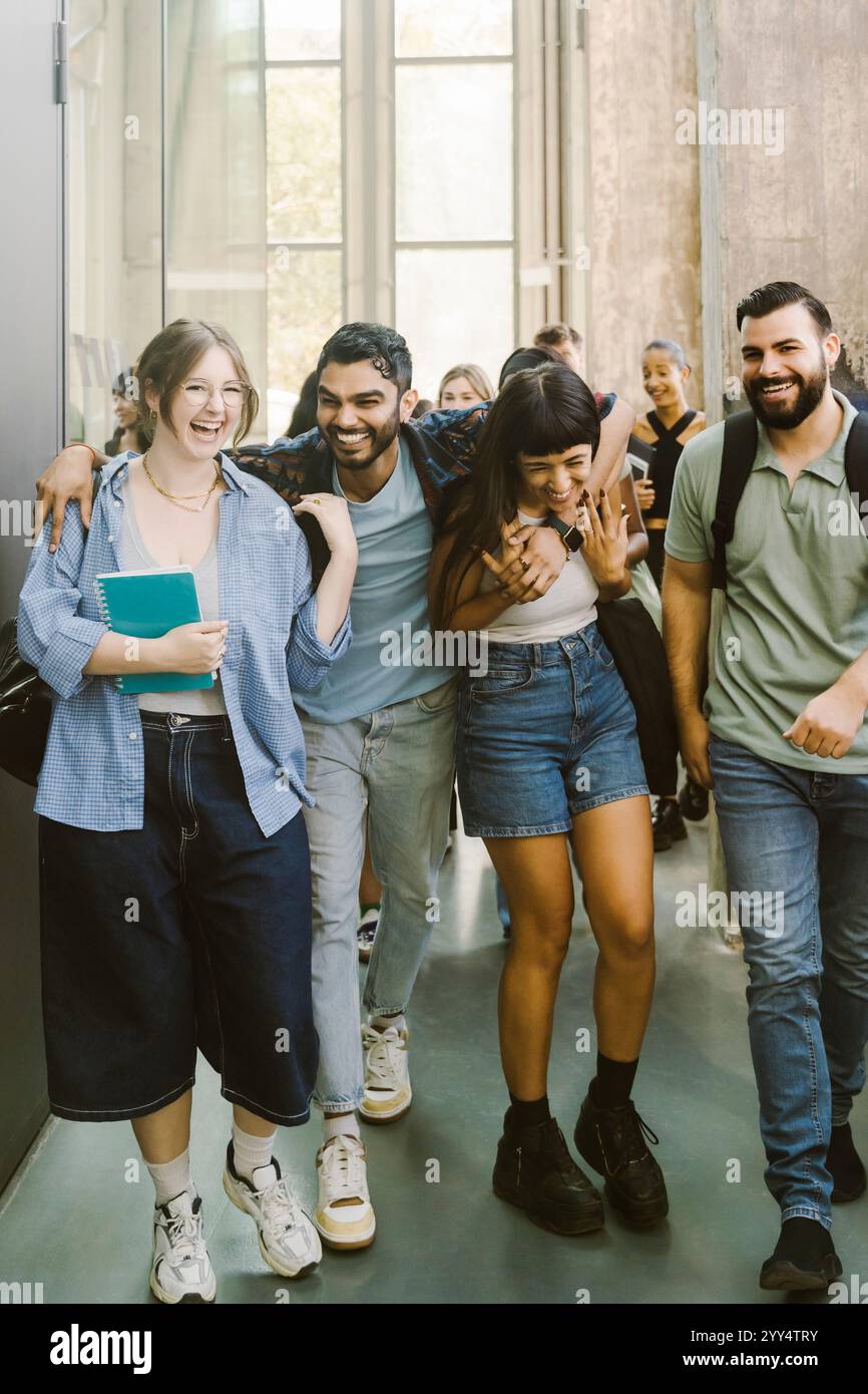 Happy man enjoying while walking with arm around female friends at ...