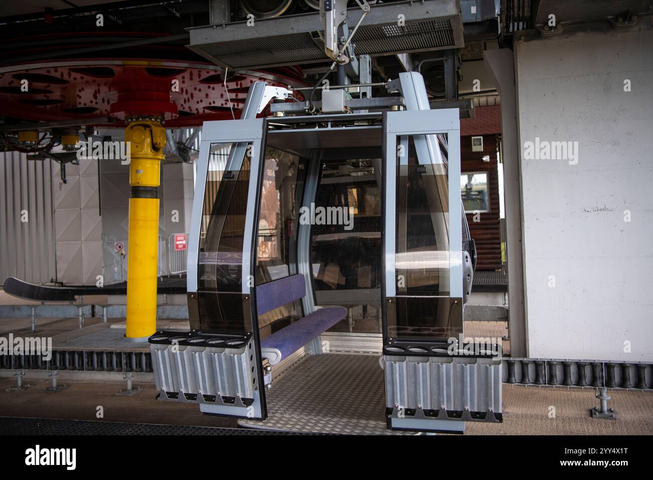 Cable car machinery station high above mountain. Metal cable and moving rollers on platform for ...