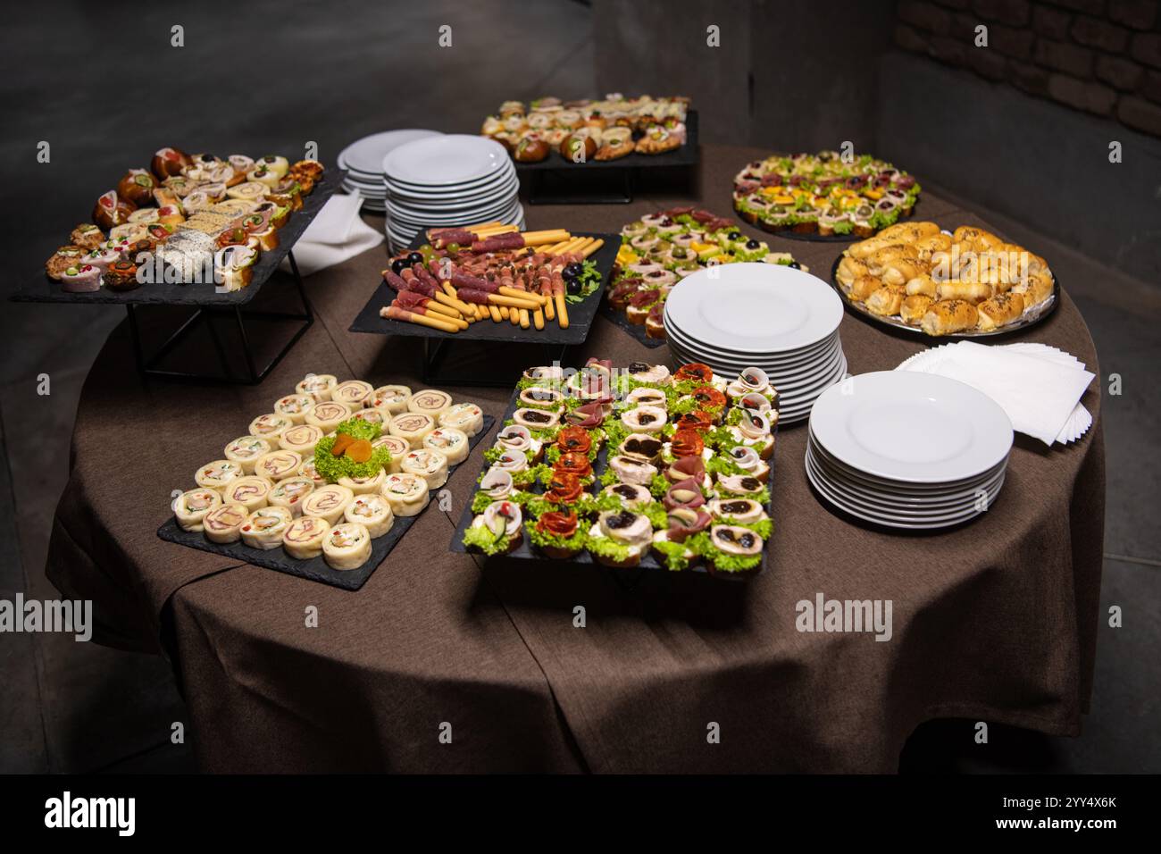 Cattering. Dark concrete business building hallway with table full of ...