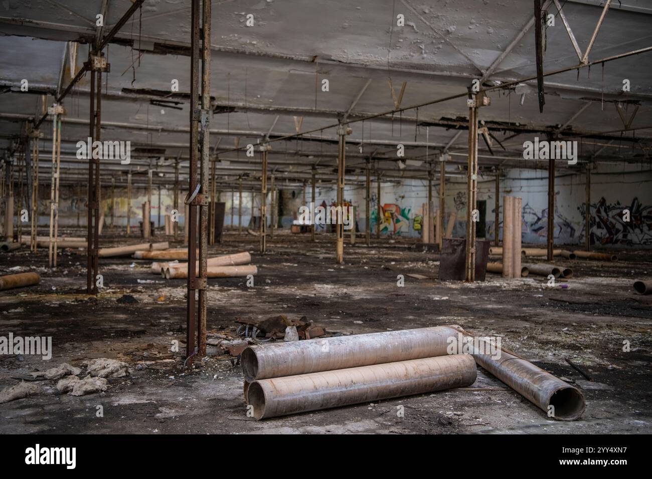 Abandoned industrial building interior. Apocalyptic scene. Ruins of large factory hangar or room ...