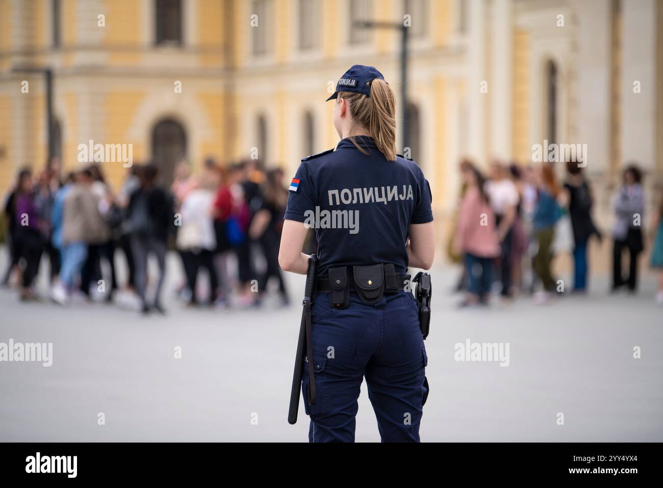 Female Police officer oversees a crowd of people on the street in ...