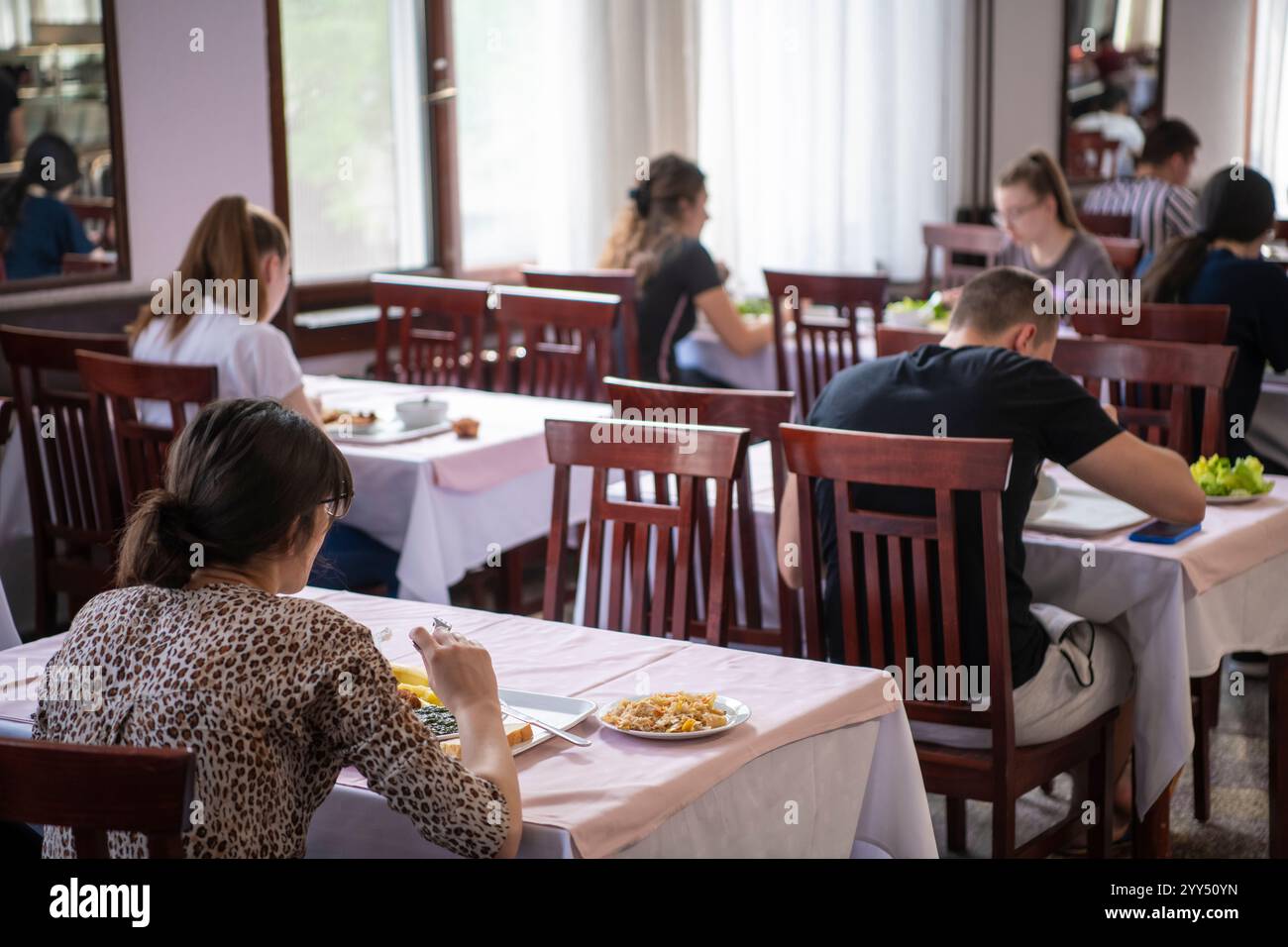 Students being served meal in school canteen. Lunch break. Education people and students eating ...