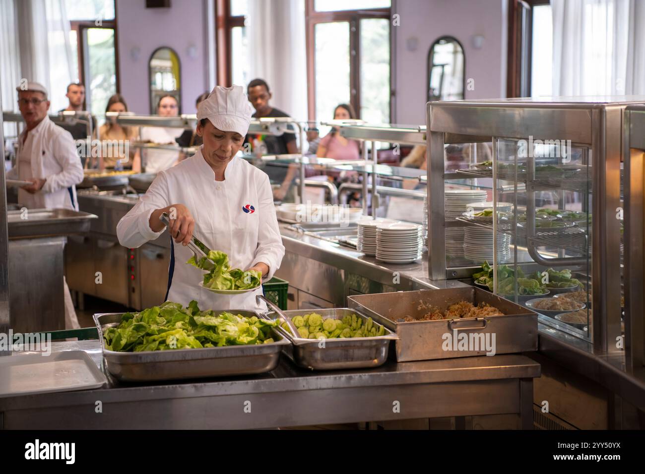 Staff worker preparing food for students in school canteen. Lunch break. Education people and ...