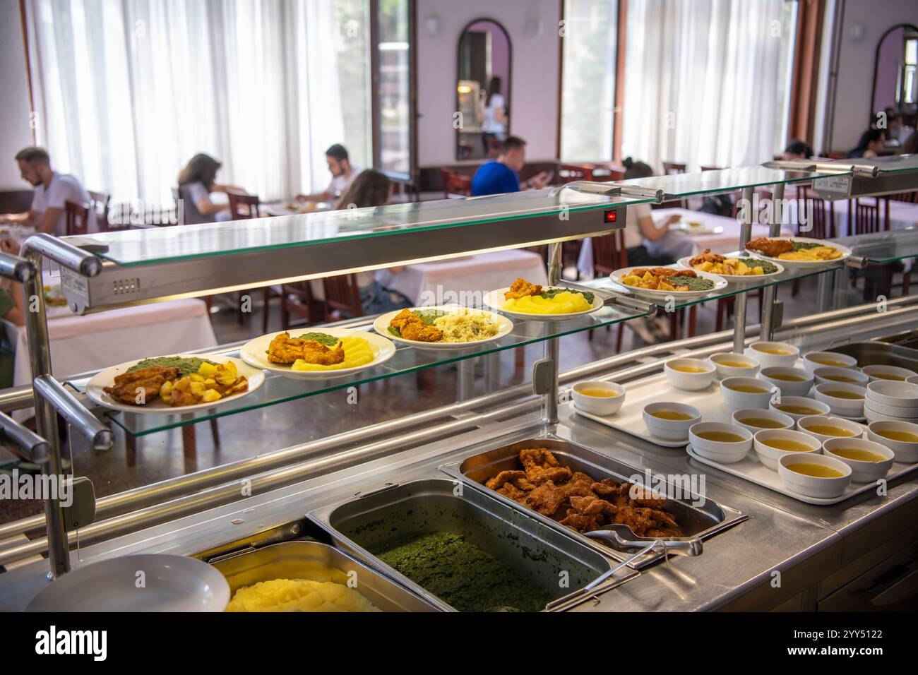 Students being served meal in school canteen. Lunch break. Education people and students eating ...