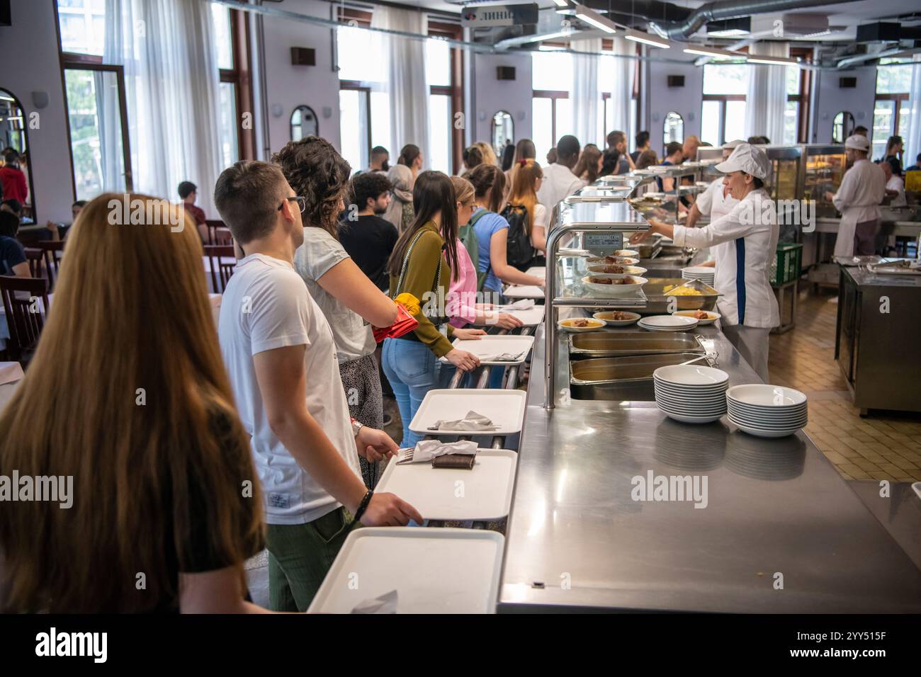 Students being served meal in school canteen. Lunch break. Education people and student in line ...