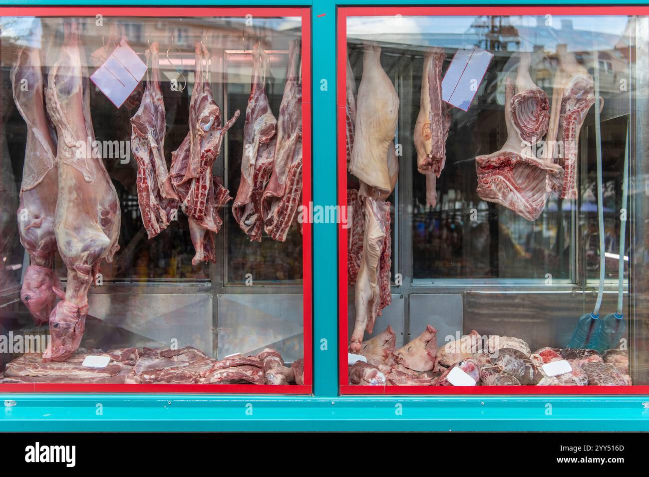Fresh hanging meat carcass on a stylish butcher shop window and its ...