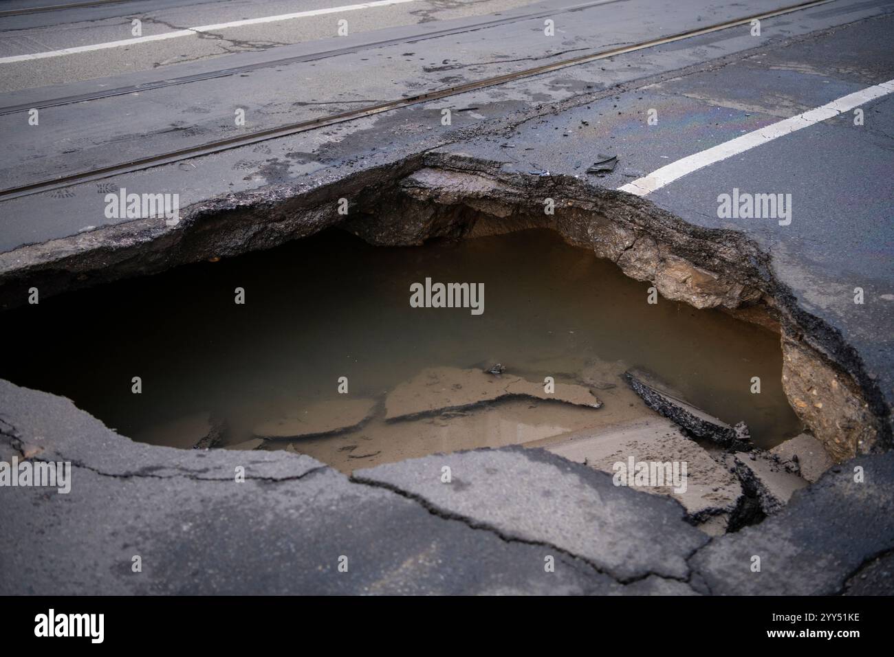 Huge sinkhole on busy asphalt road surface on which cars drive ...