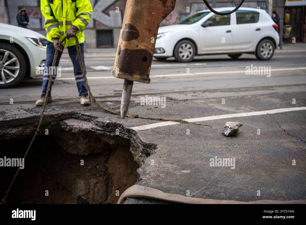 Road construction worker with machines repair Huge sinkhole on busy ...