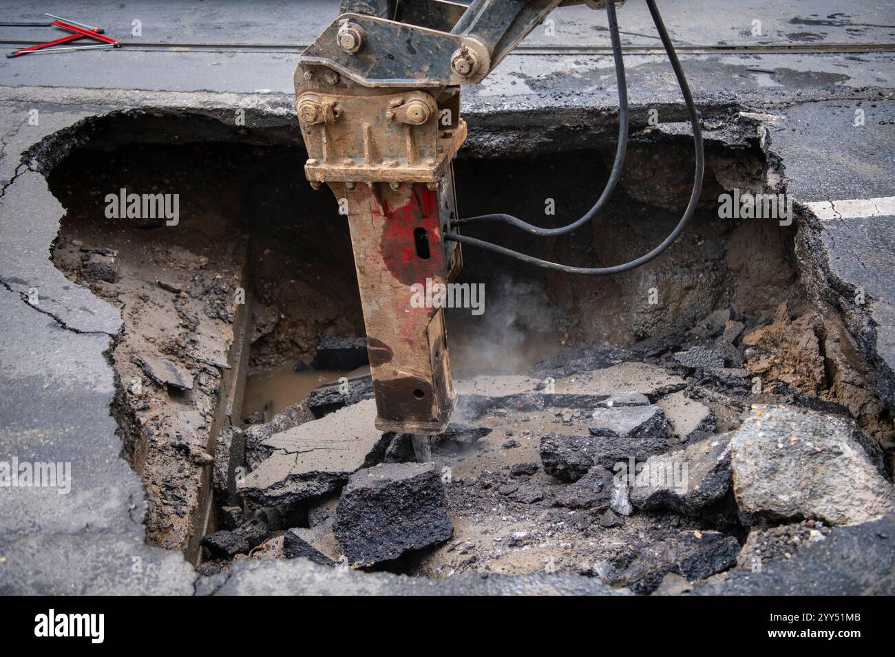 Road construction worker with machines repair Huge sinkhole on busy ...