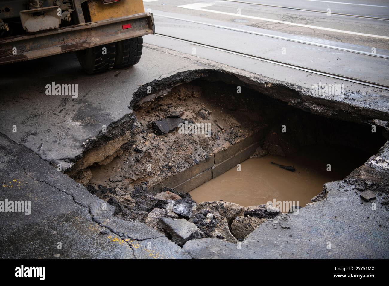 Huge sinkhole on busy asphalt road surface on which cars drive ...