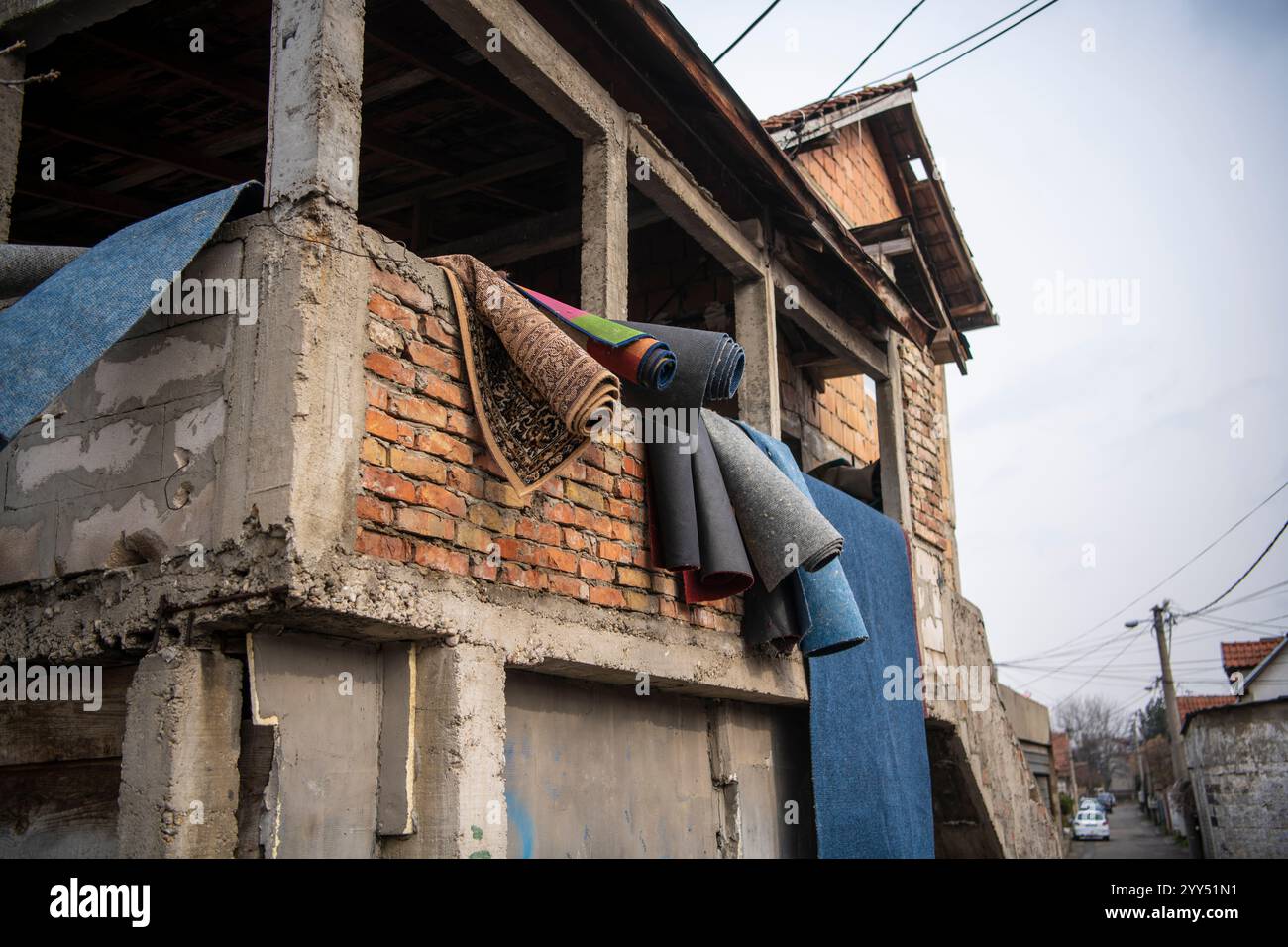Pile of used old rug and carpets in rolls, hanging over terrace of old ...
