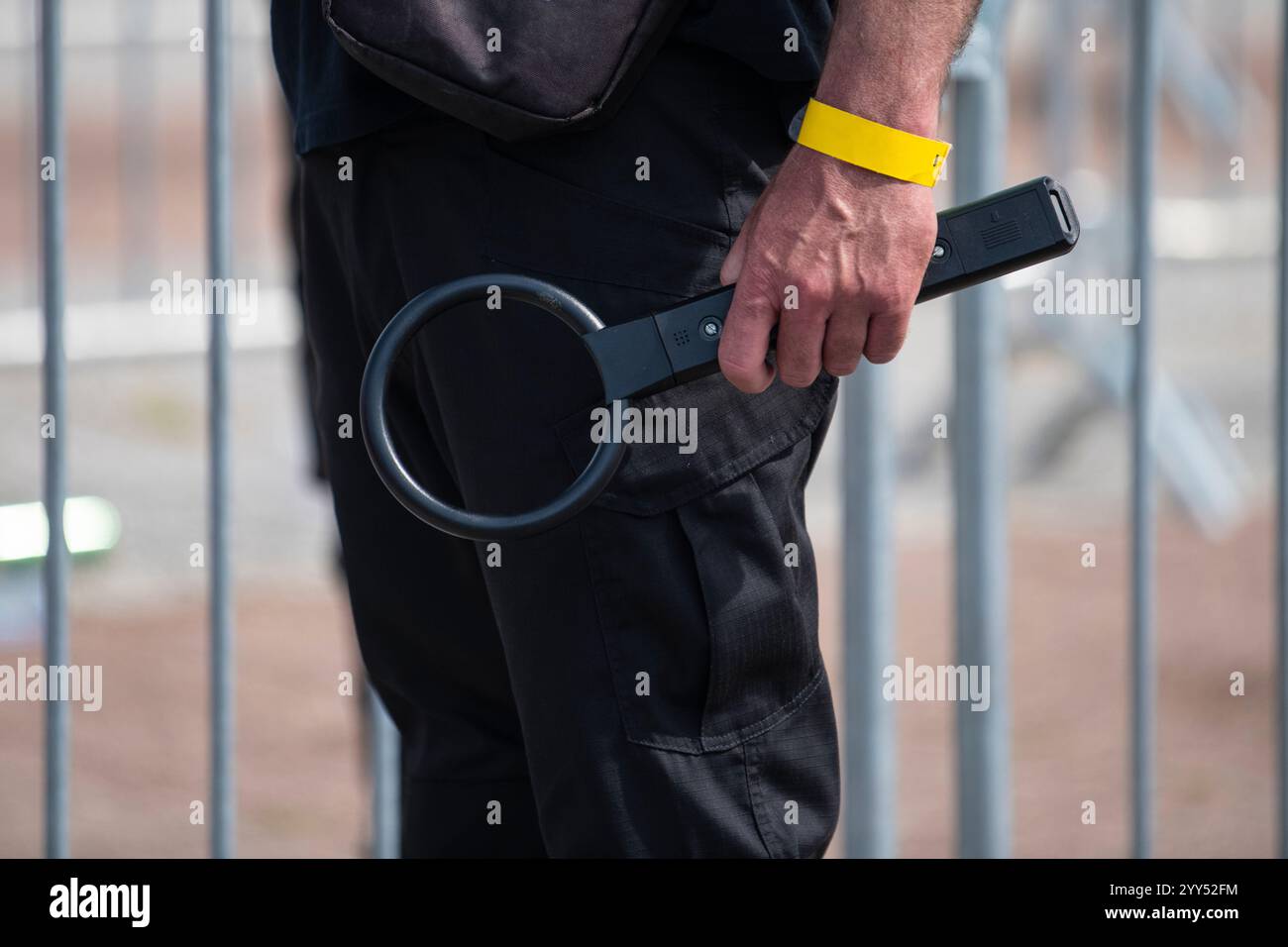 Security check metal detector device in hand of staff worker on check ...