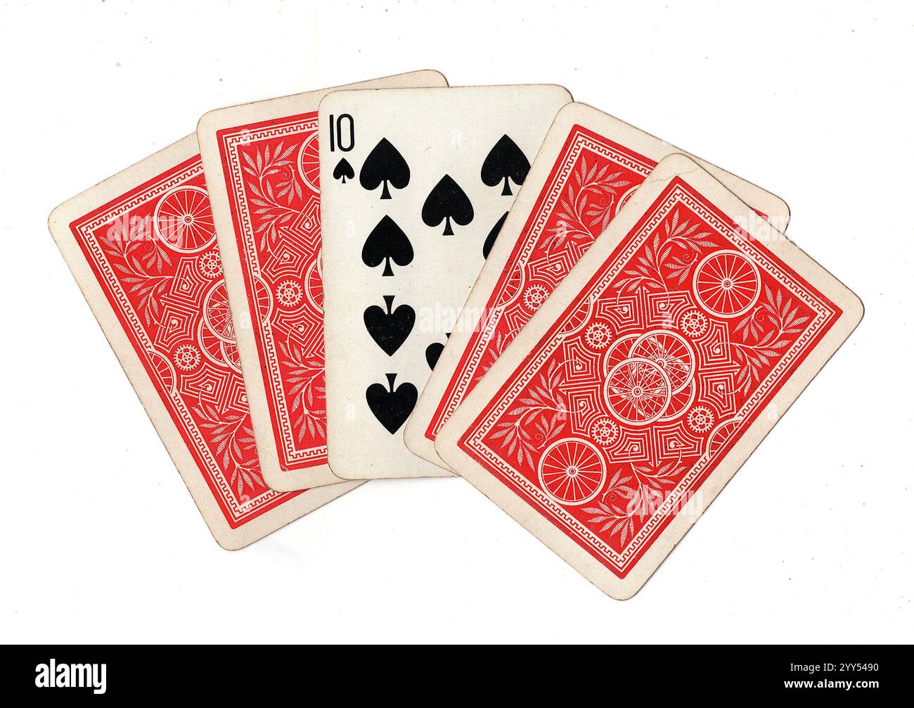A hand of vintage playing card backs with the ten of spades revealed on ...