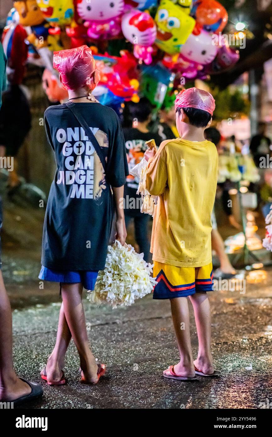Young filipino boys sell flower garlands to worshippers outside the ...
