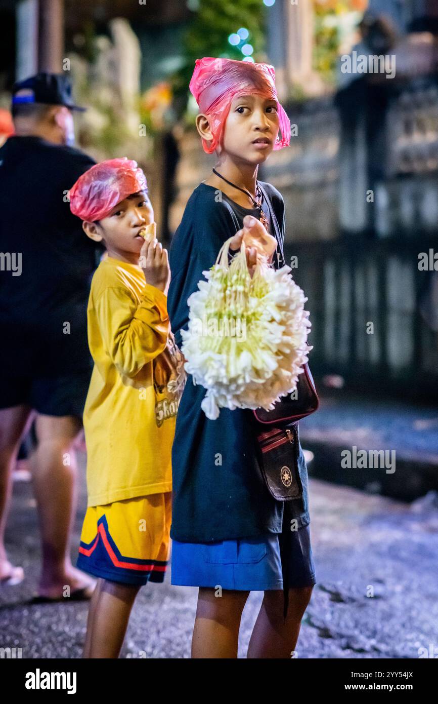 Young filipino boys sell flower garlands to worshippers outside the ...